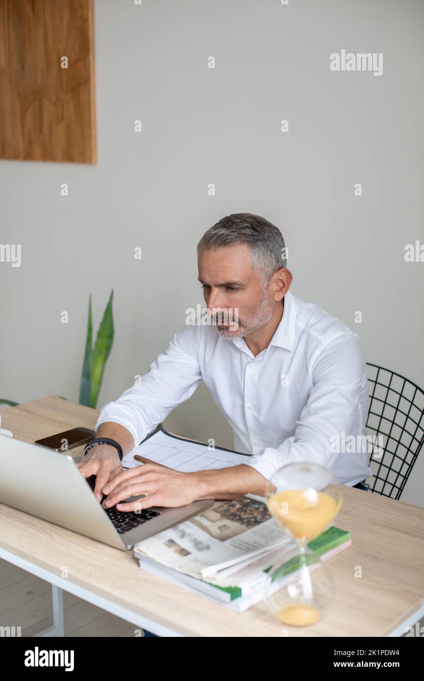 CEO sitting at his working place and working on the laptop Stock Photo ...