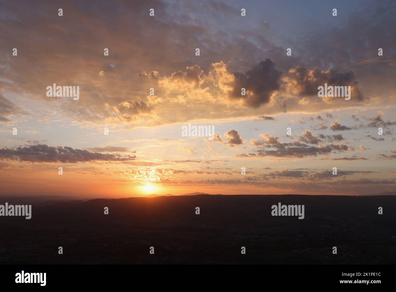 Last rays of sun against backdrop of plains and mountains Stock Photo ...