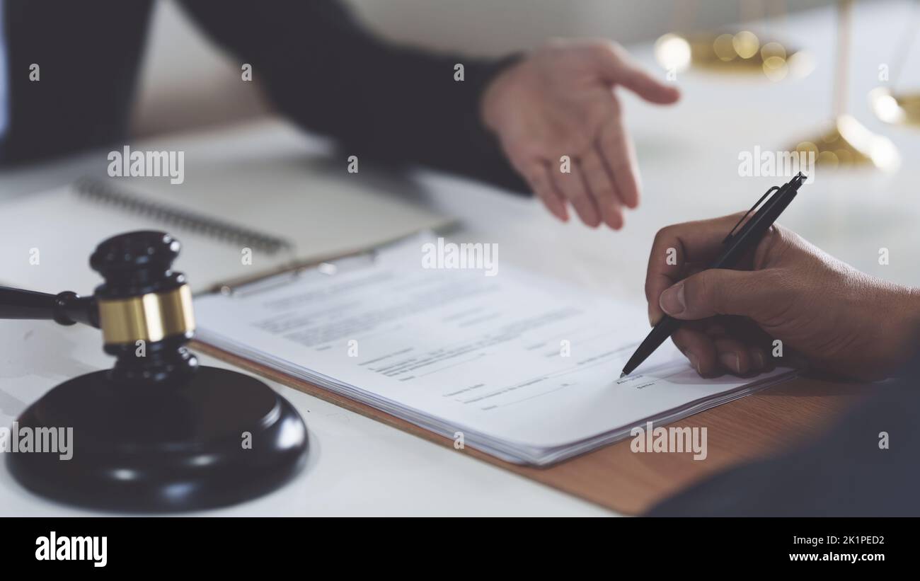 Business woman and lawyers discussing contract papers with brass scale ...