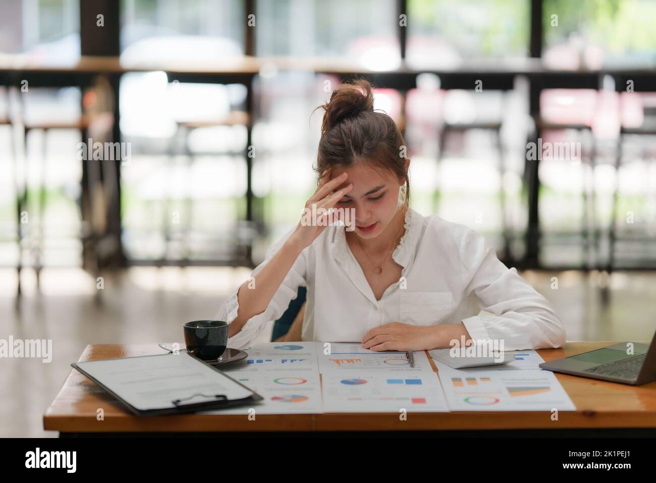 Stressed Asian business woman worry with many document on desk at ...