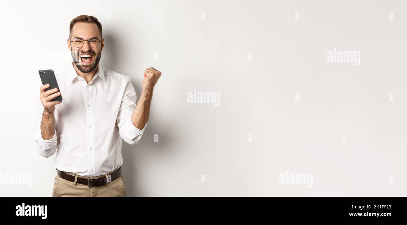 Successful businessman looking happy, fist pump and rejoice in winning ...