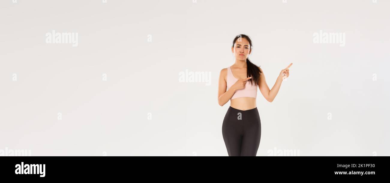 Full length of skeptical, disappointed asian fitness girl, sportswoman ...