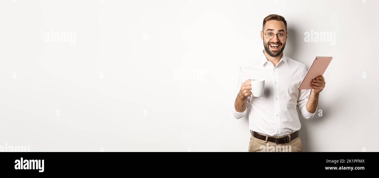 Excited manager reading on digital tablet, working and drinking coffee ...