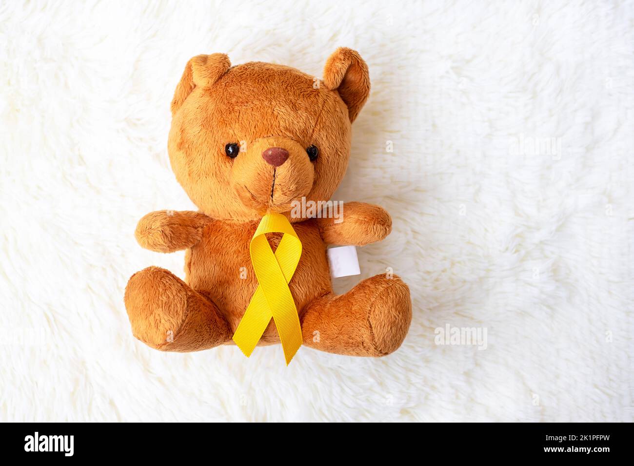 Yellow Ribbon with Bear doll on white background for supporting kid ...