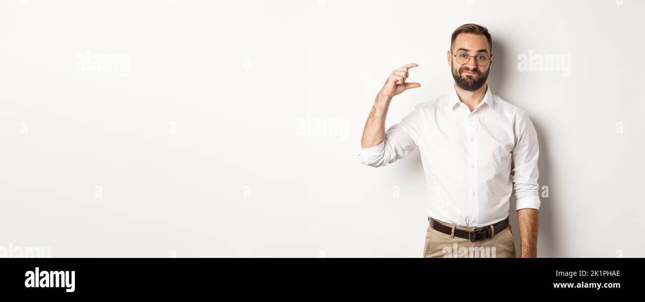Displeased bearded businessman showing small gesture, looking ...