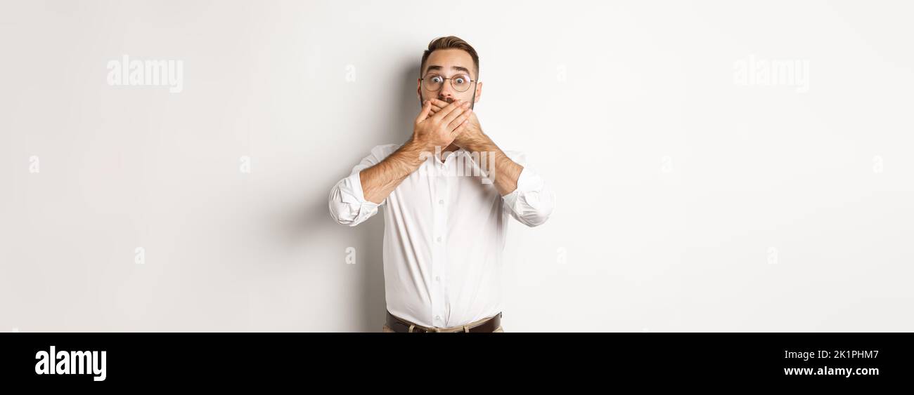 Shocked man gasping and looking at something in awe, covering mouth ...