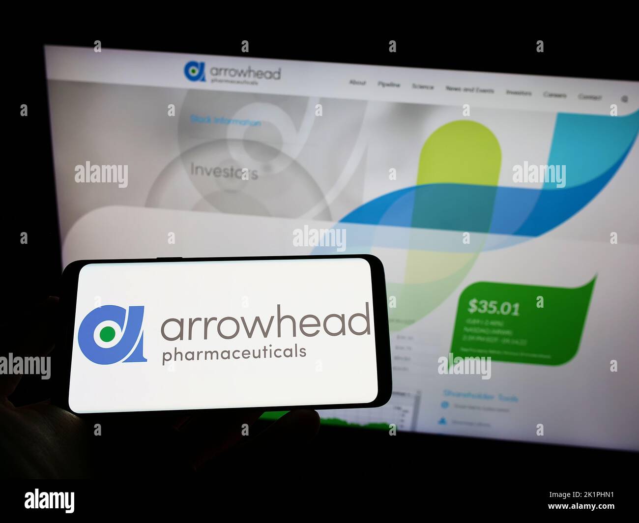 Person holding mobile phone with logo of American company Arrowhead ...