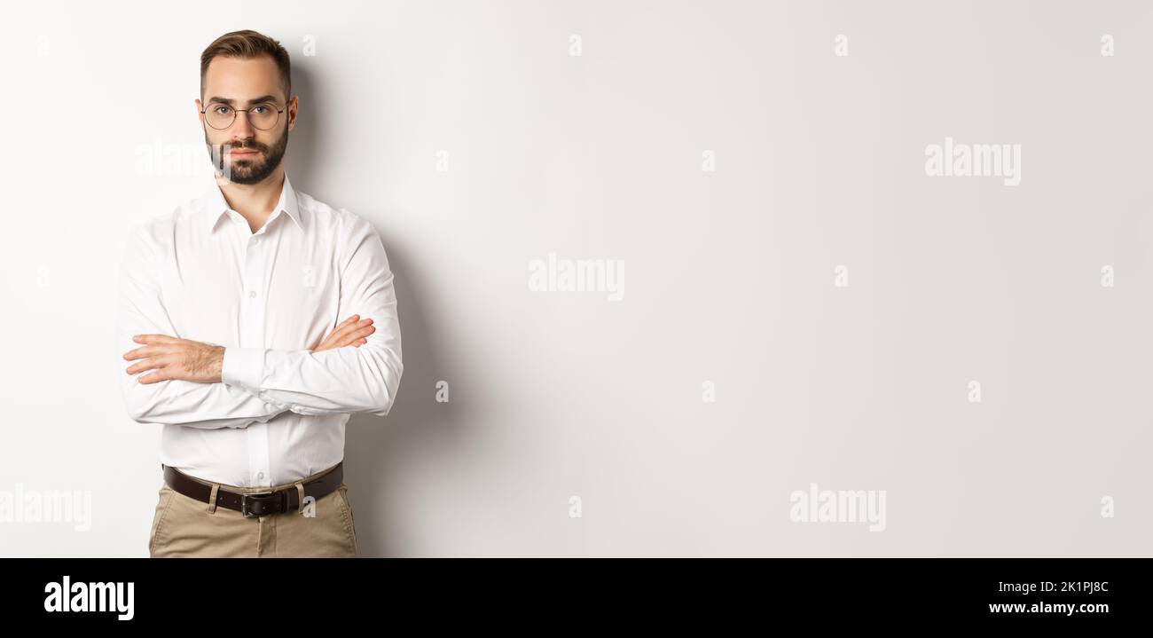 Confident businessman in glasses looking at camera, cross arms on chest ...