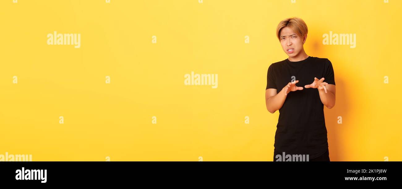 Portrait of disgusted picky asian guy, refusing and grimacing, standing ...