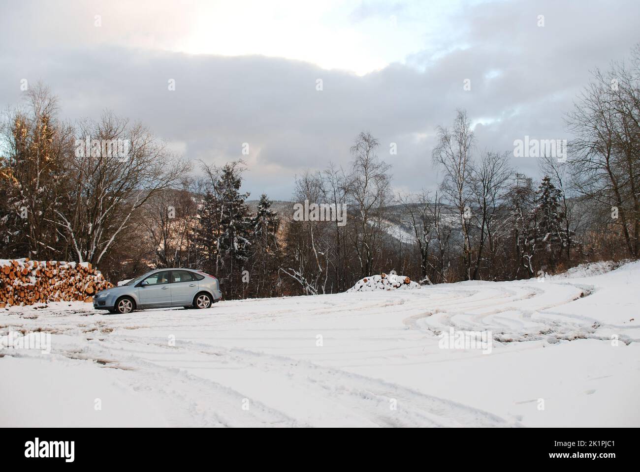A gray car driving on a trail through a snowy white forest Stock Photo ...