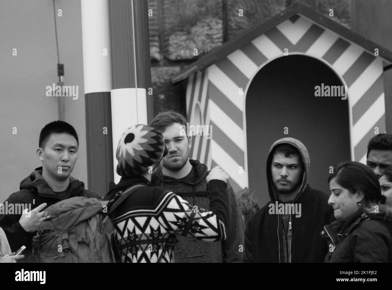 A grayscale shot of a tour group looking grimly at the guide in Prague ...
