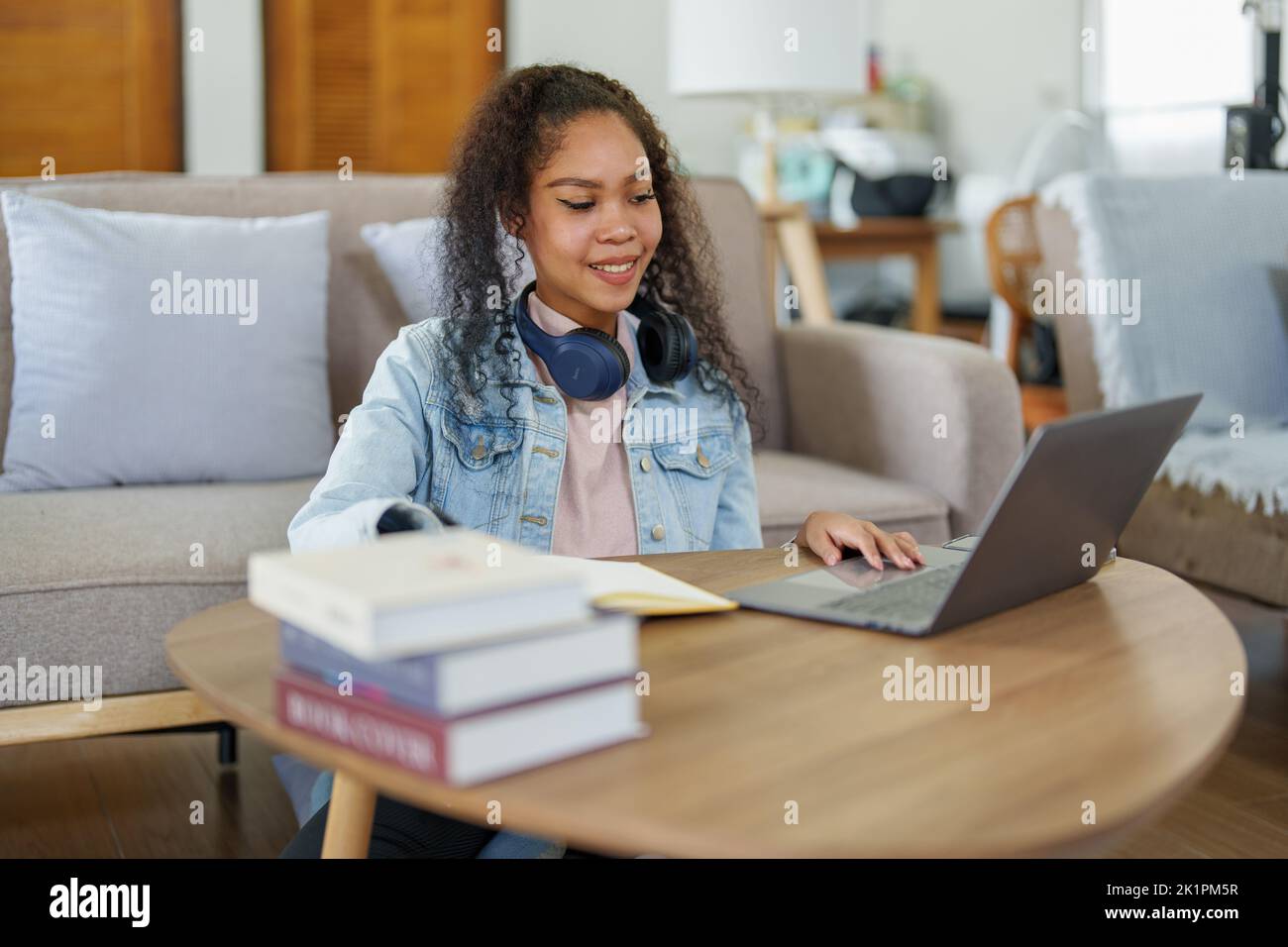 African American using a notebook and computer to study online at home ...