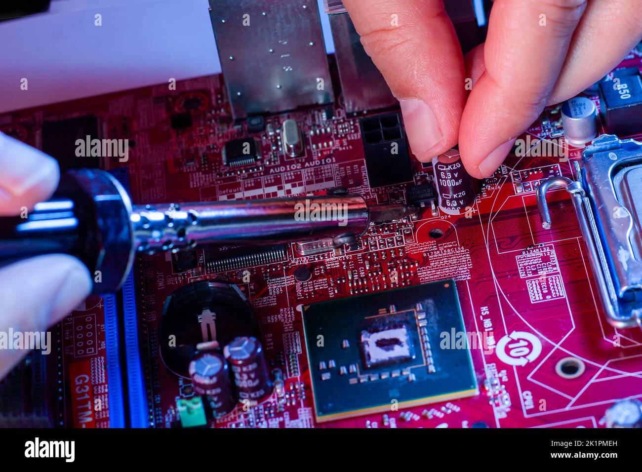 A man soldering a motherboard. Repair and maintenance of desktop ...