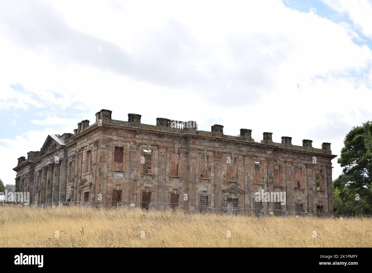 A low-angle shot of Sutton Scarsdale hall with yellowing grass around ...
