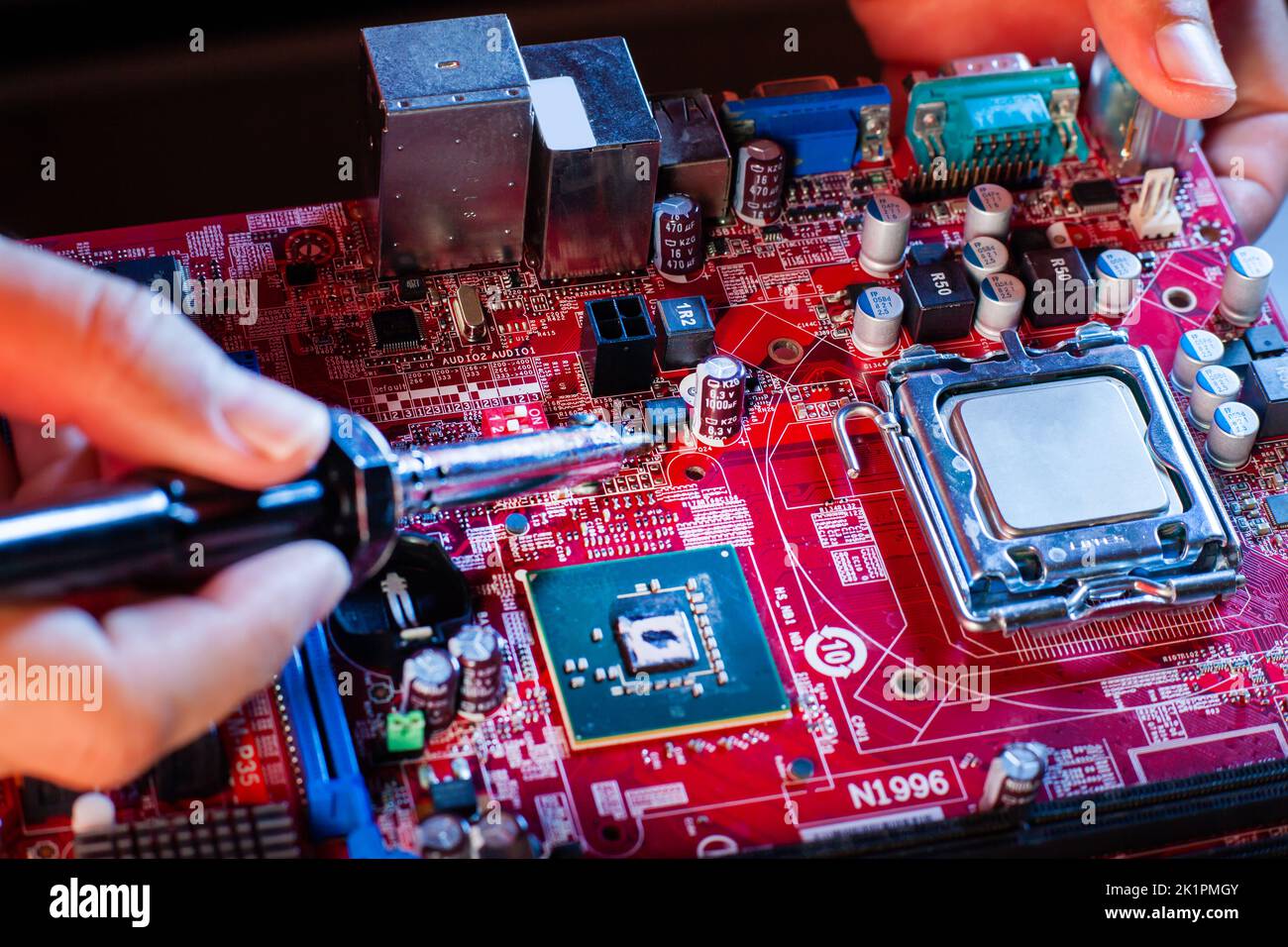 A man soldering a motherboard. Repair and maintenance of desktop ...