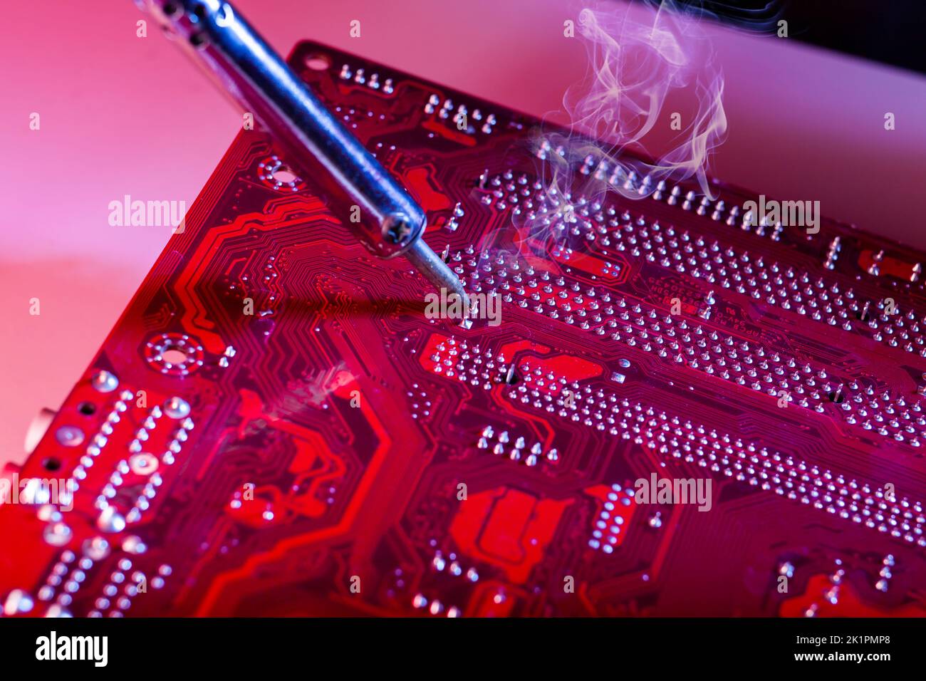 A man soldering a motherboard. Repair and maintenance of desktop ...