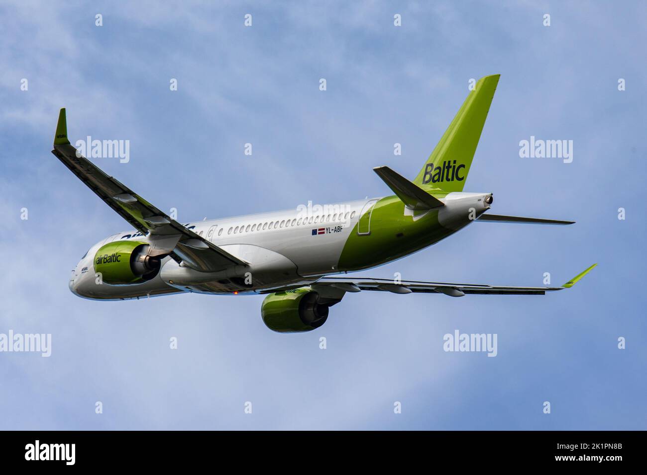 A closeup of an air Baltic airplane against a white cloudy sky ...