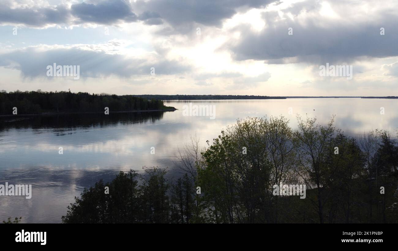 An aerial drone view of a beautiful lake surrounded by green trees ...