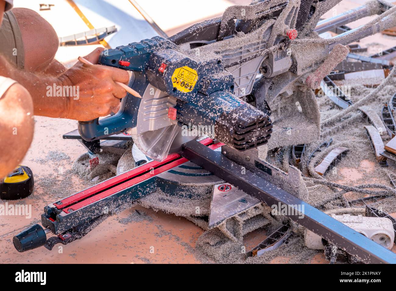 Miter saw. Cutting of PVC profile for siding. Sawdust Stock Photo - Alamy