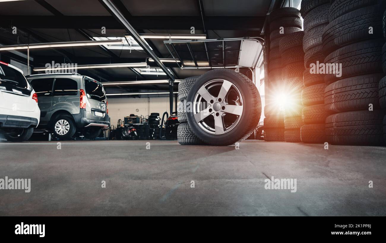 tire at repairing service garage background. Technician man replacing ...
