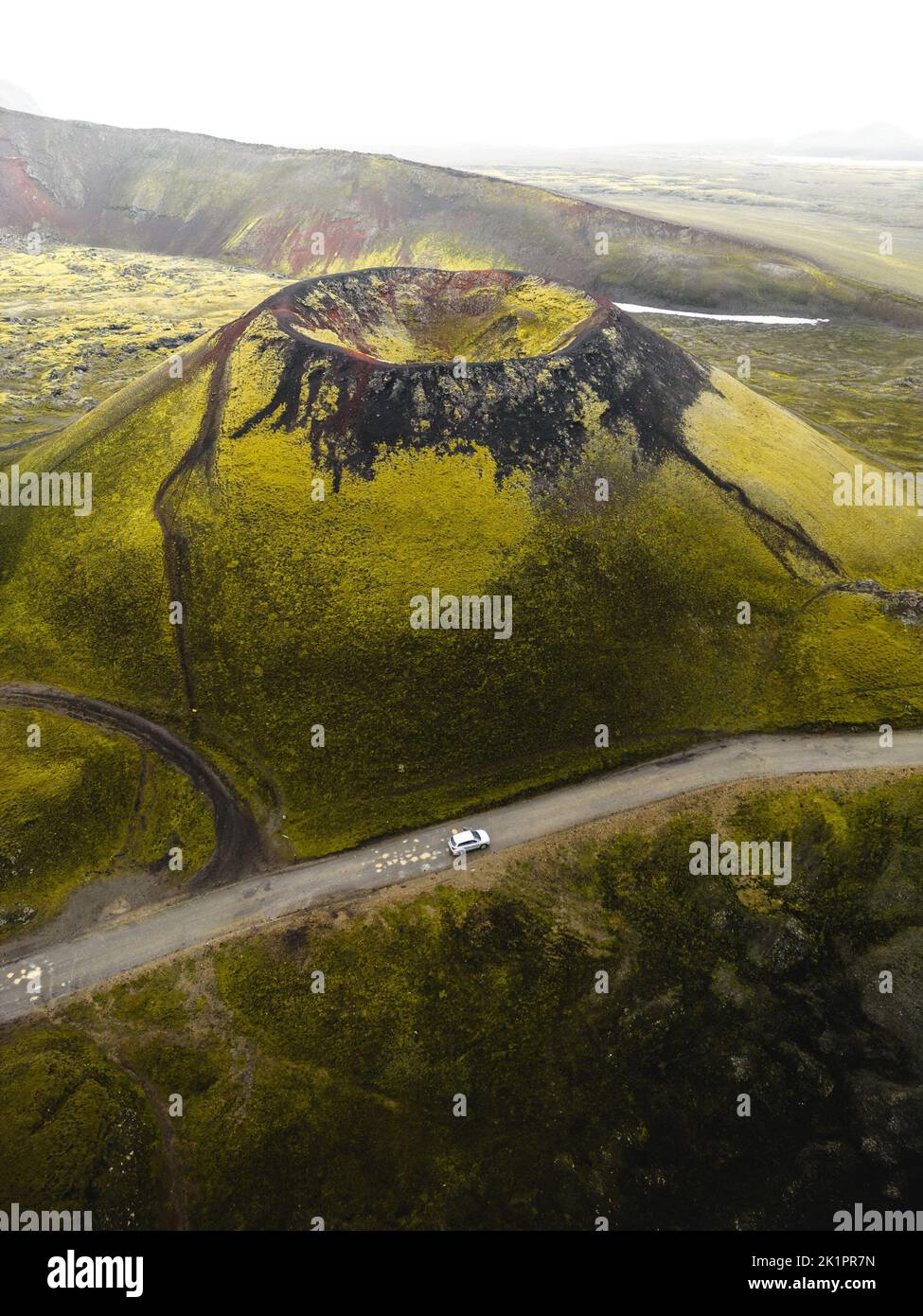 An aerial view of Laki volcano surrounded by greenery hills with road ...