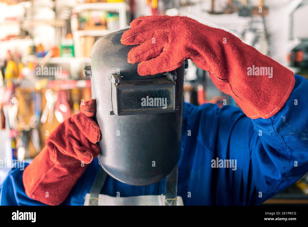 A man welder putting helmet for protect the eyes. Worker wearing a ...
