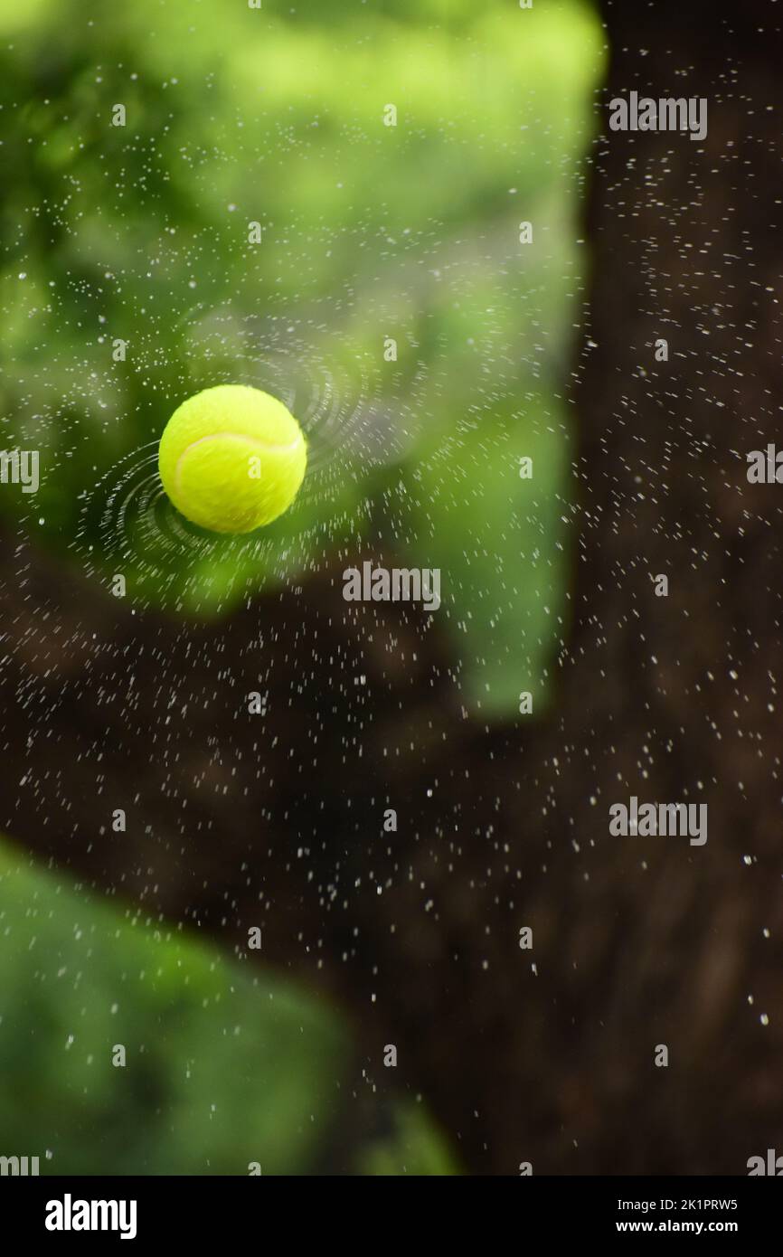 A vertical shot of the spinning tennis ball with splashed water Stock ...