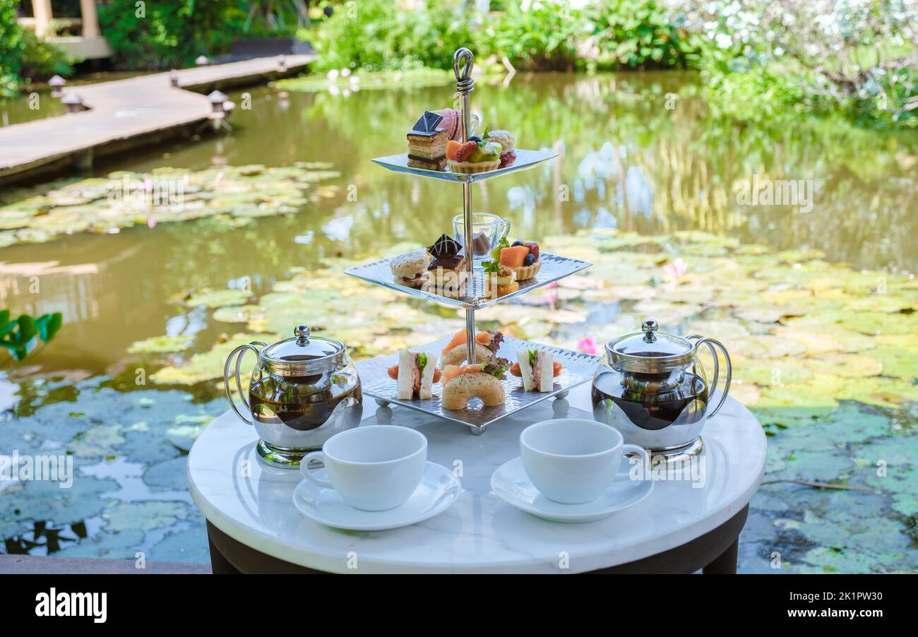 Afternoon tea at a water pond, high tea in a tropical garden in Thailand Stock Photo - Alamy