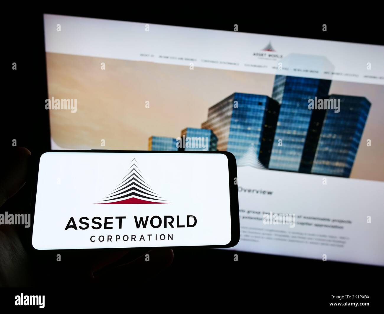 Person holding mobile phone with logo of Thai real estate company Asset ...