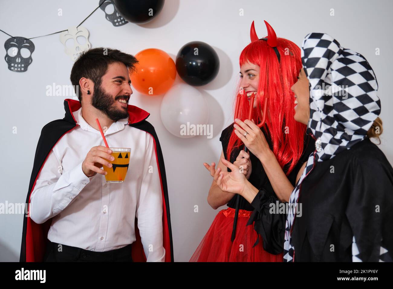 Three people talking and laughing at a costume Halloween party Stock ...