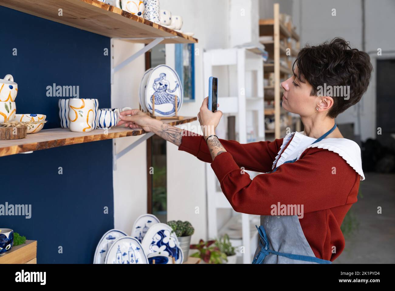 Girl artist shooting clay shaping raw clay mug in pottery studio of ...
