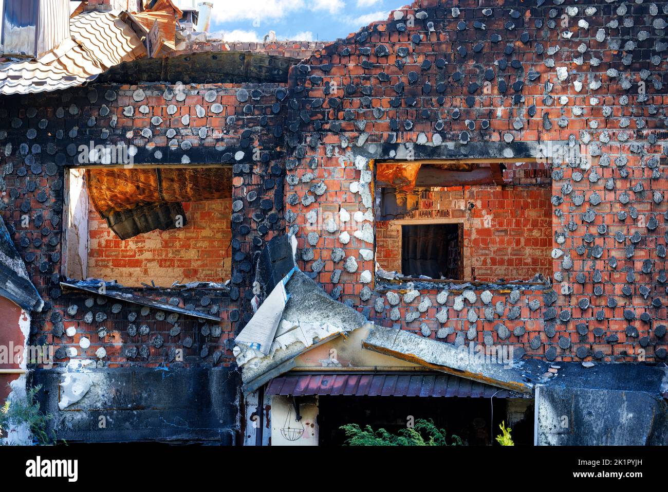 Empty window sockets of a burnt-out rural house after a rocket attack ...