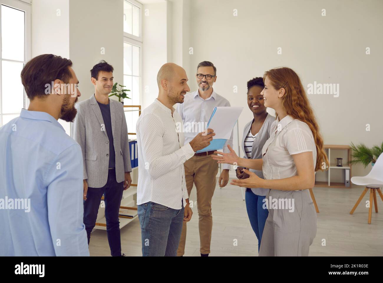 Positive male manager of company in morning in office gives tasks to ...