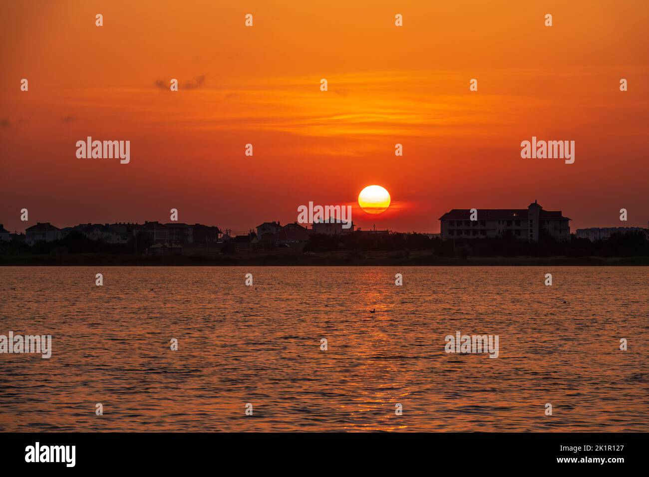 The sun goes down over a lake. Dramatic Sunset Sky Stock Photo - Alamy