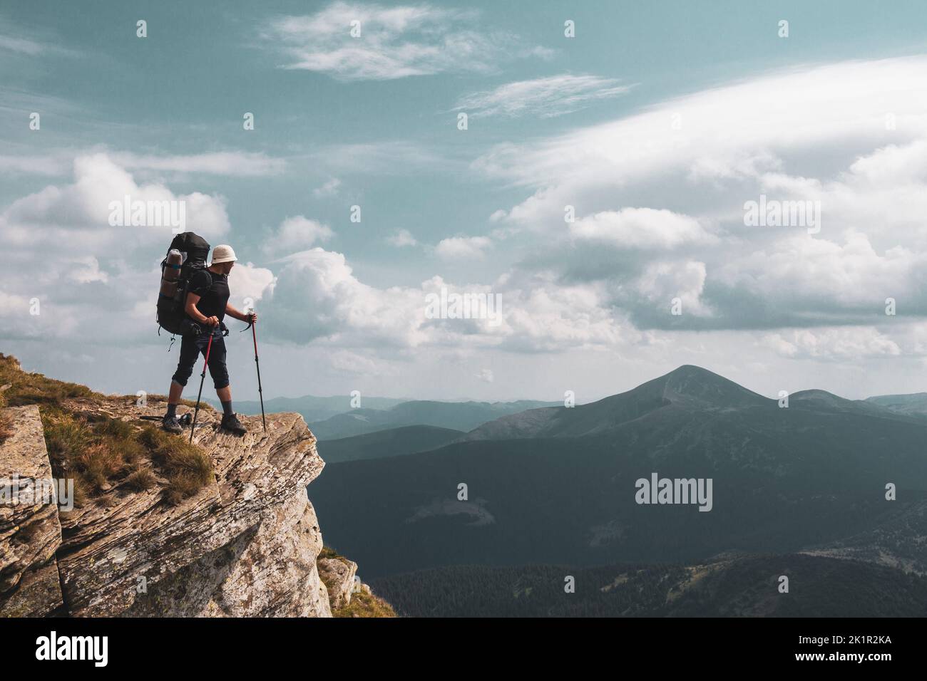 Hiker on the cliff with beautiful mountain chain on the background ...