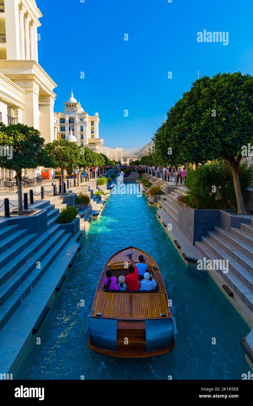 A vertical shot of a wooden boat floating in a channel in The Land of ...