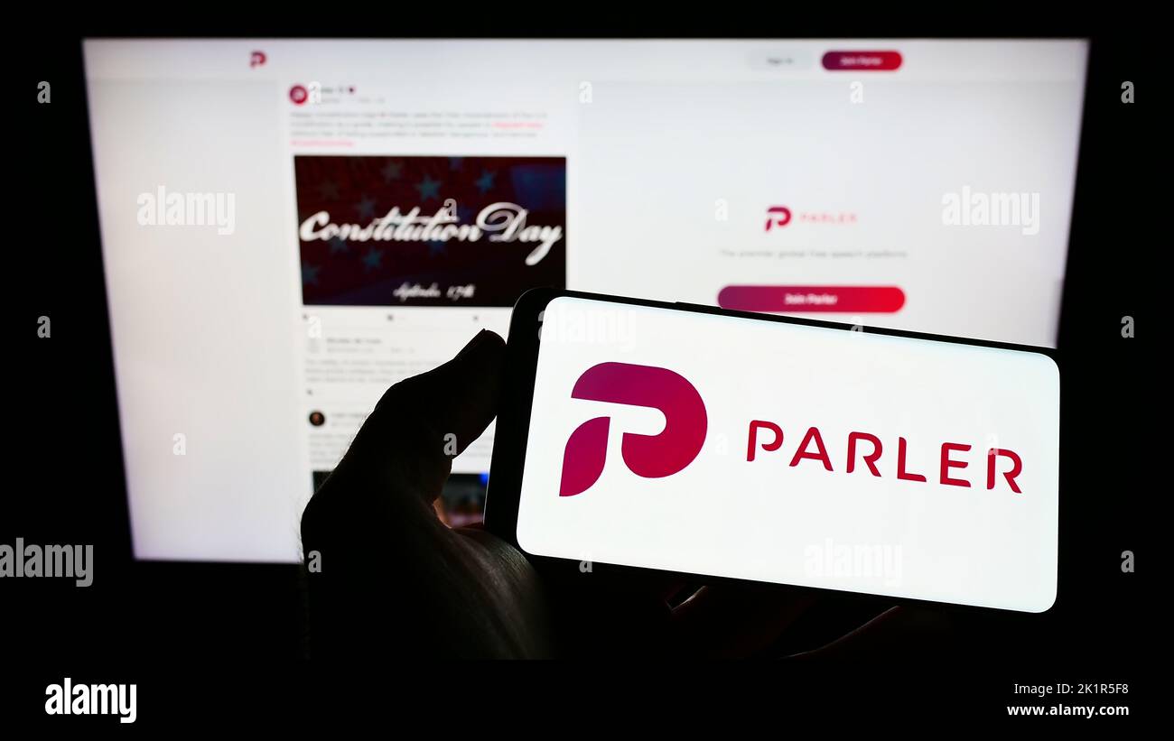 Person holding mobile phone with logo of American social networking ...