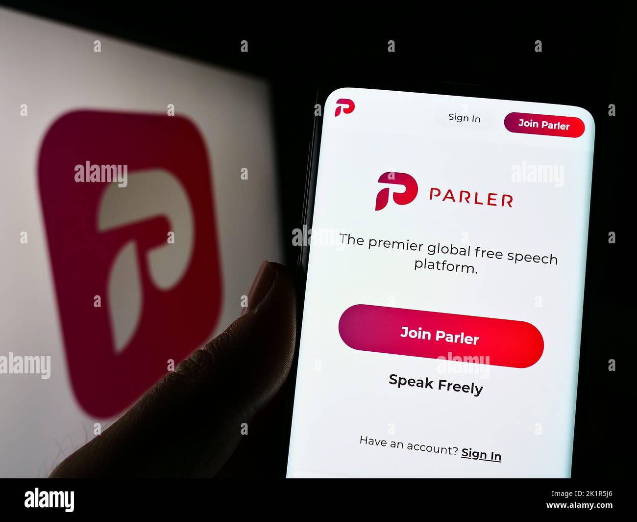 Person holding cellphone with webpage of US social networking company ...