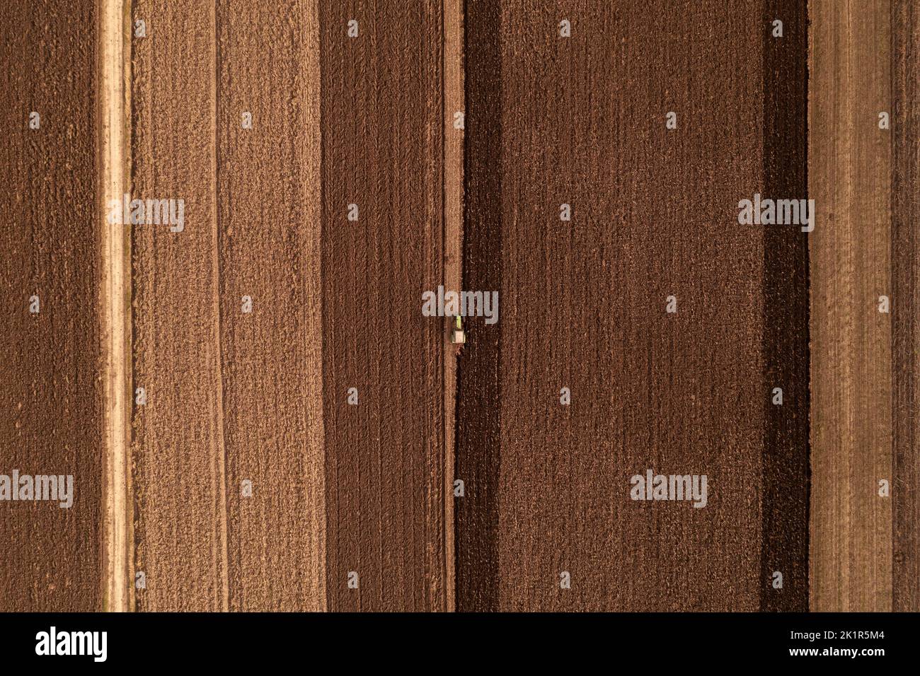 Aerial view of farmland field tillage with tractor, drone photography ...