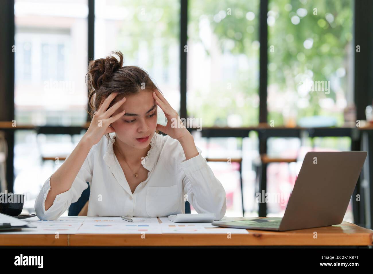 Stressed Asian business woman worry with many document on desk at ...
