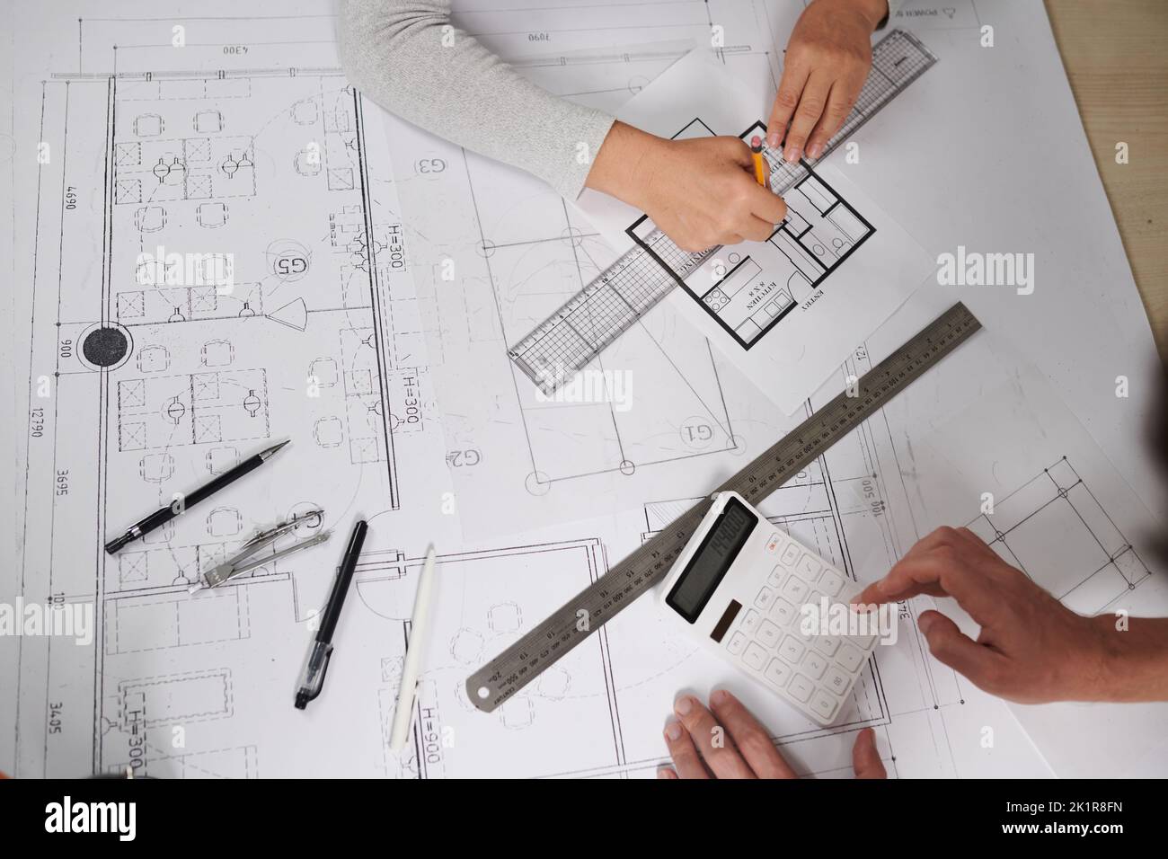 Hands of architects working on blueprint of building, view from above ...