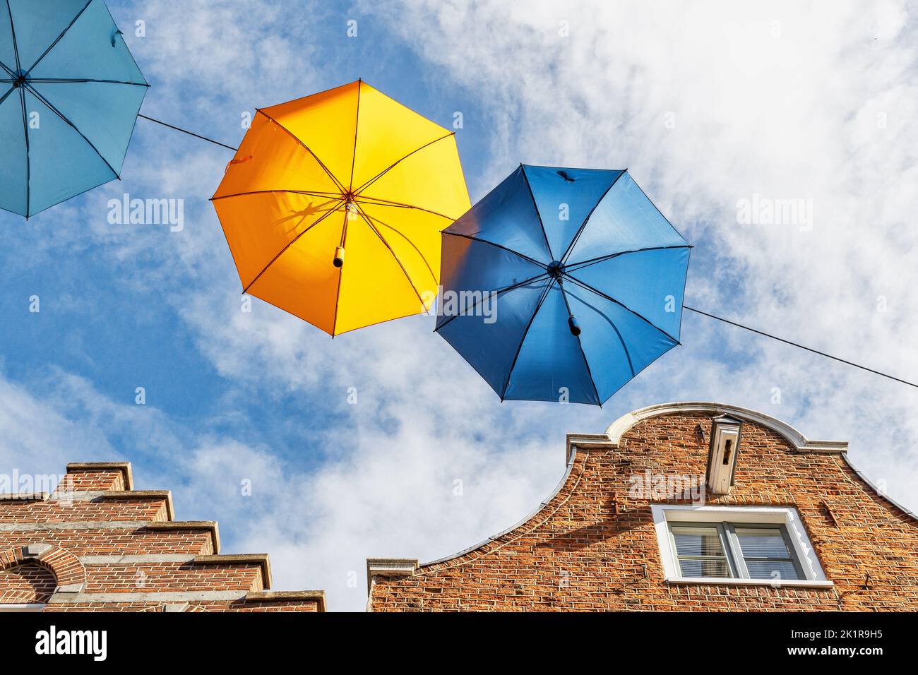 Colorful umbrellas in the air against blue sky with clouds Stock Photo ...