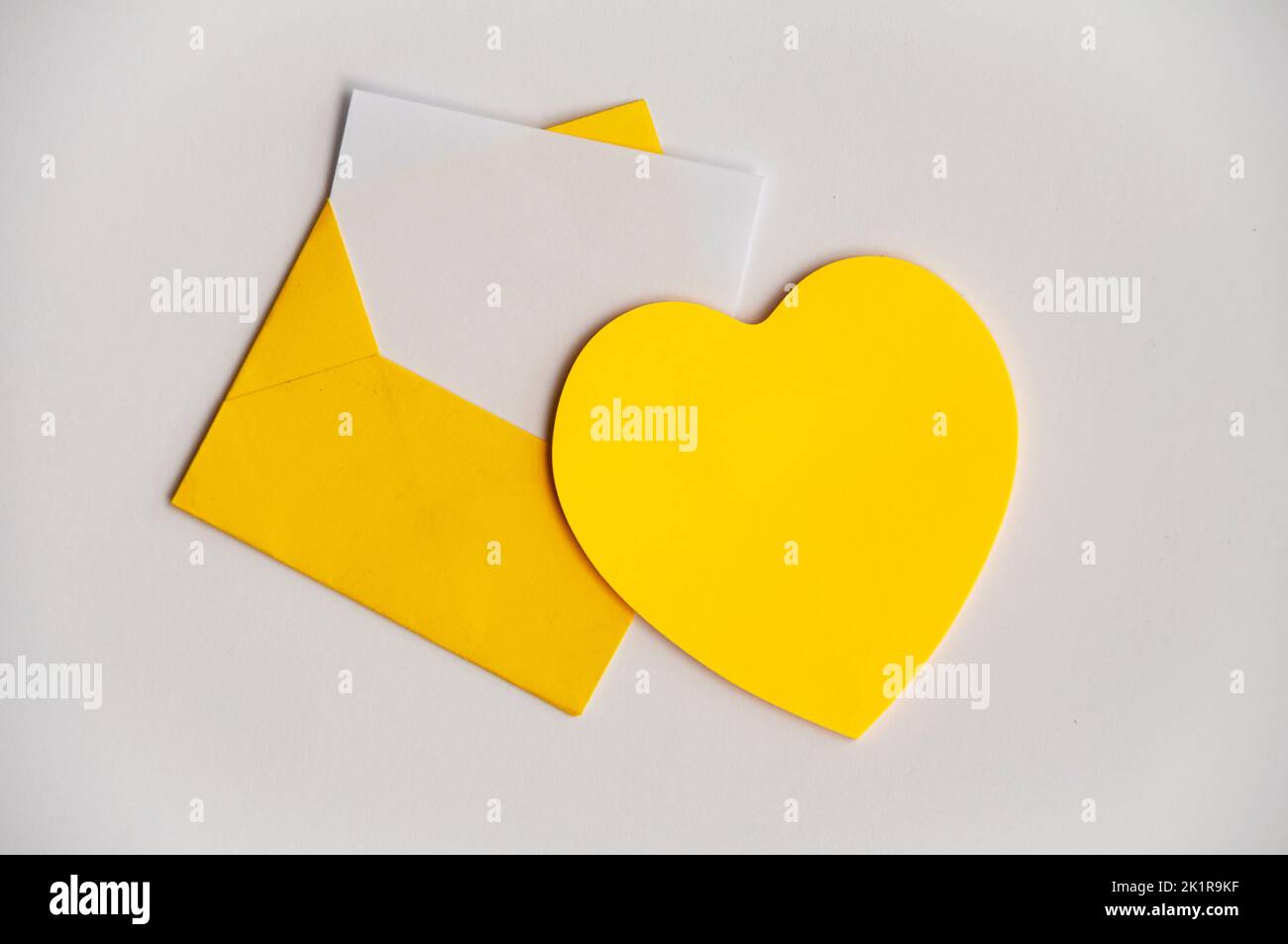 Blank heart shape notepad with envelope on white background with ...