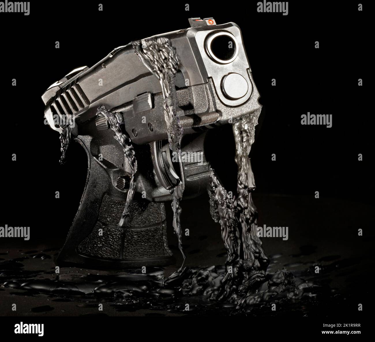 Melting semi-auto pistol on a black background Stock Photo - Alamy