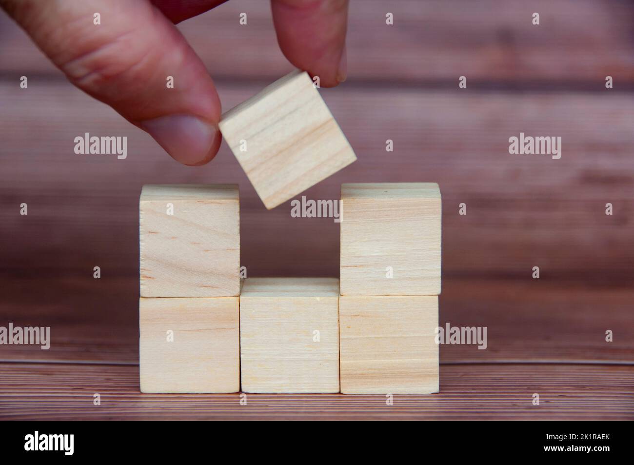 Hand placing wooden block with customizable space for text or ideas ...