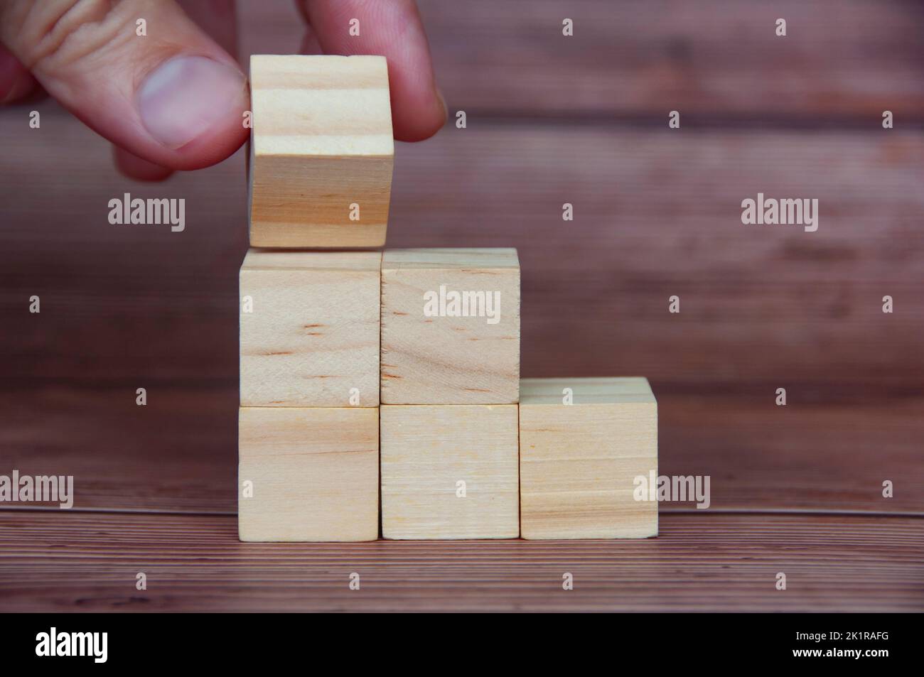 Hand turning a wooden block with customizable space for text or ideas ...