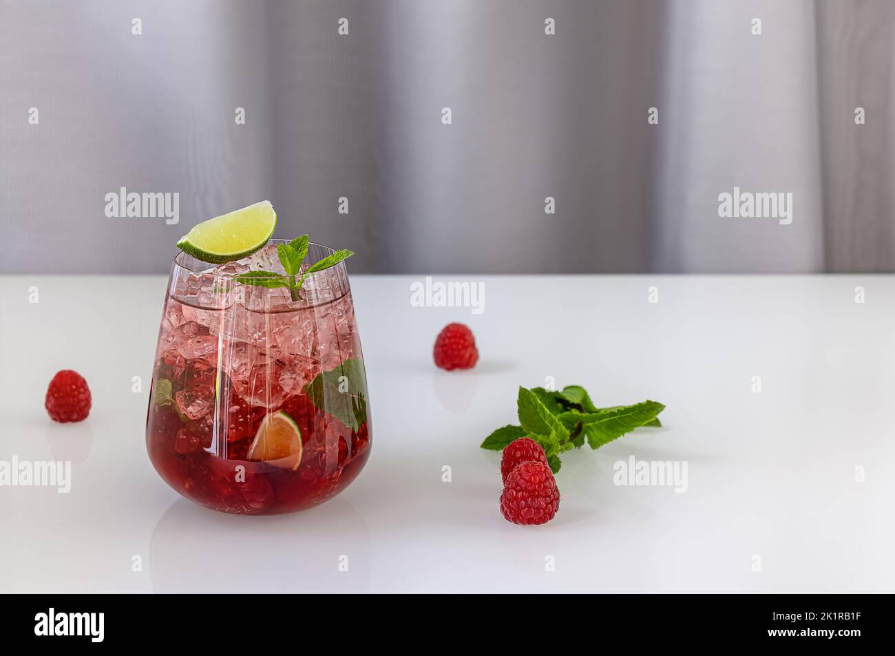A glass of raspberry daiquiri, alcoholic cocktail or mocktail with raspberry, soda water, lime ...