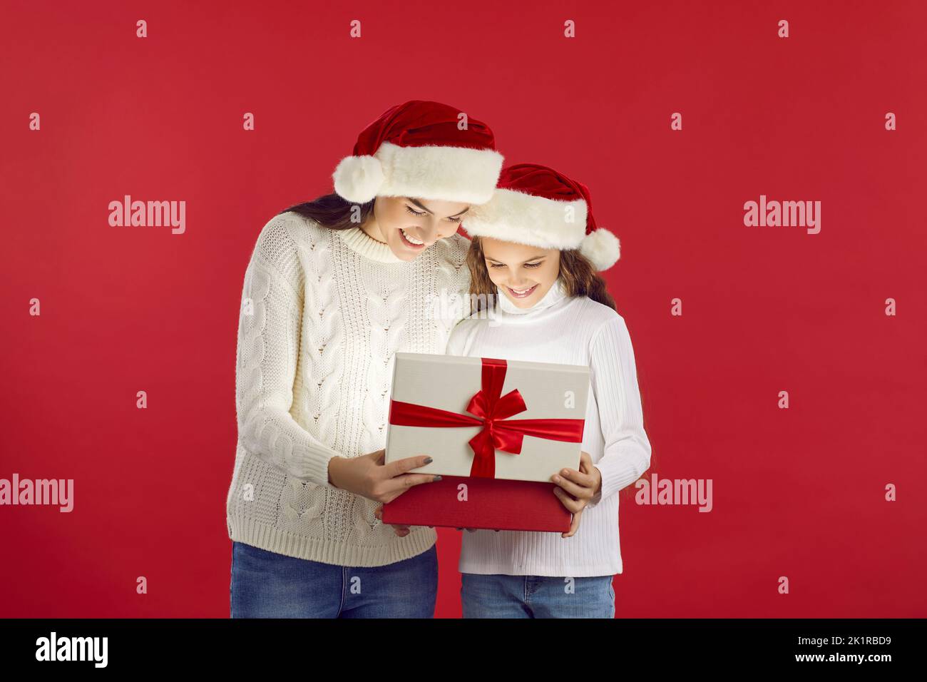 Studio portrait of happy mother and daughter opening box with magic ...