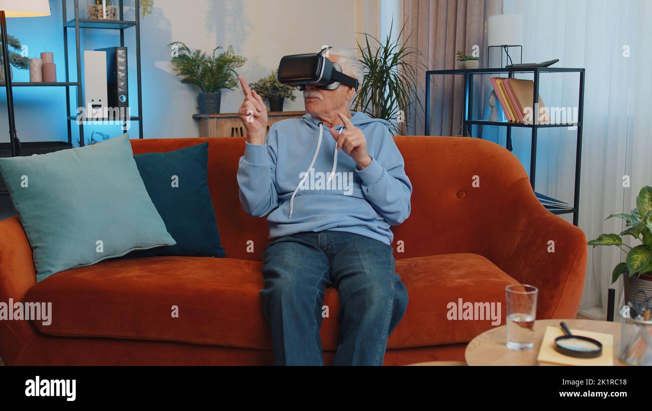 Senior old grandfather using virtual reality futuristic technology VR ...