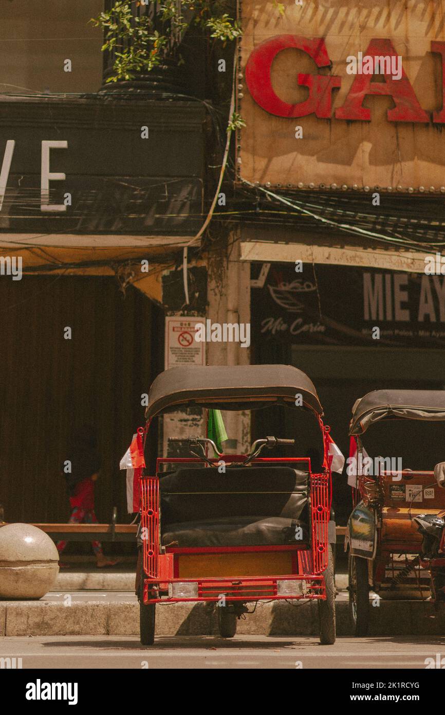 A vertical shot of a traditional tricycle parked on the side of a ...